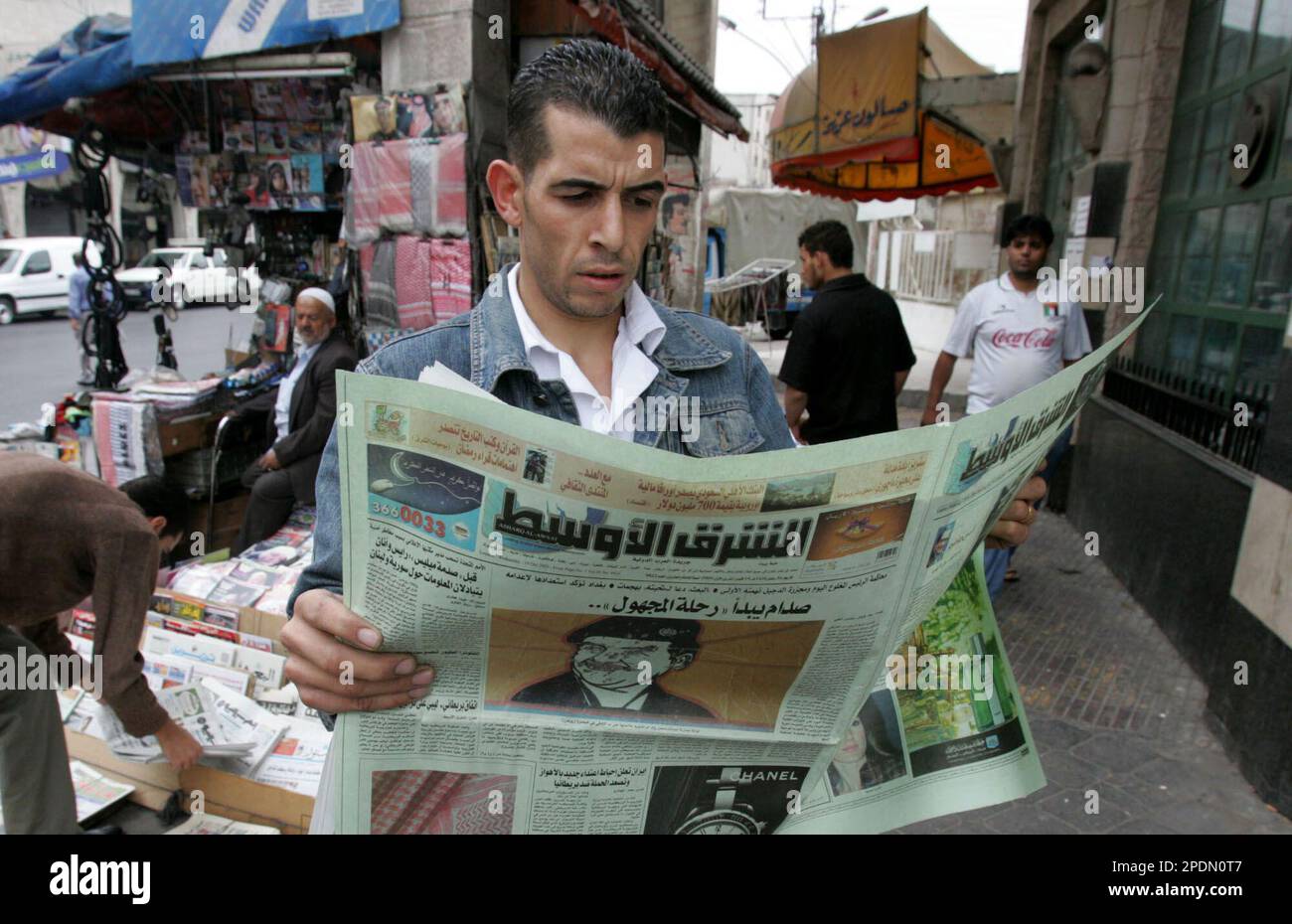 A Jordanian man reads a newspaper with a picture of former Iraqi leader ...