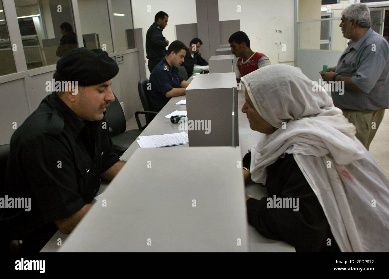 A Palestinian police officer checks the documents of a Plestinian woman ...