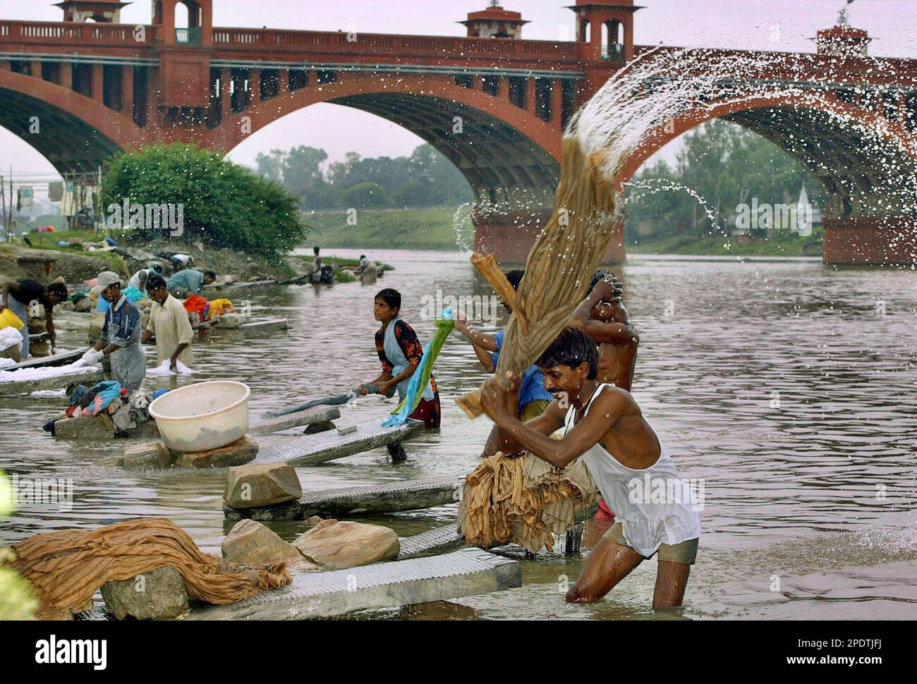 Dhobis, or washermen, wash clothes on the banks of the River Gomti in ...