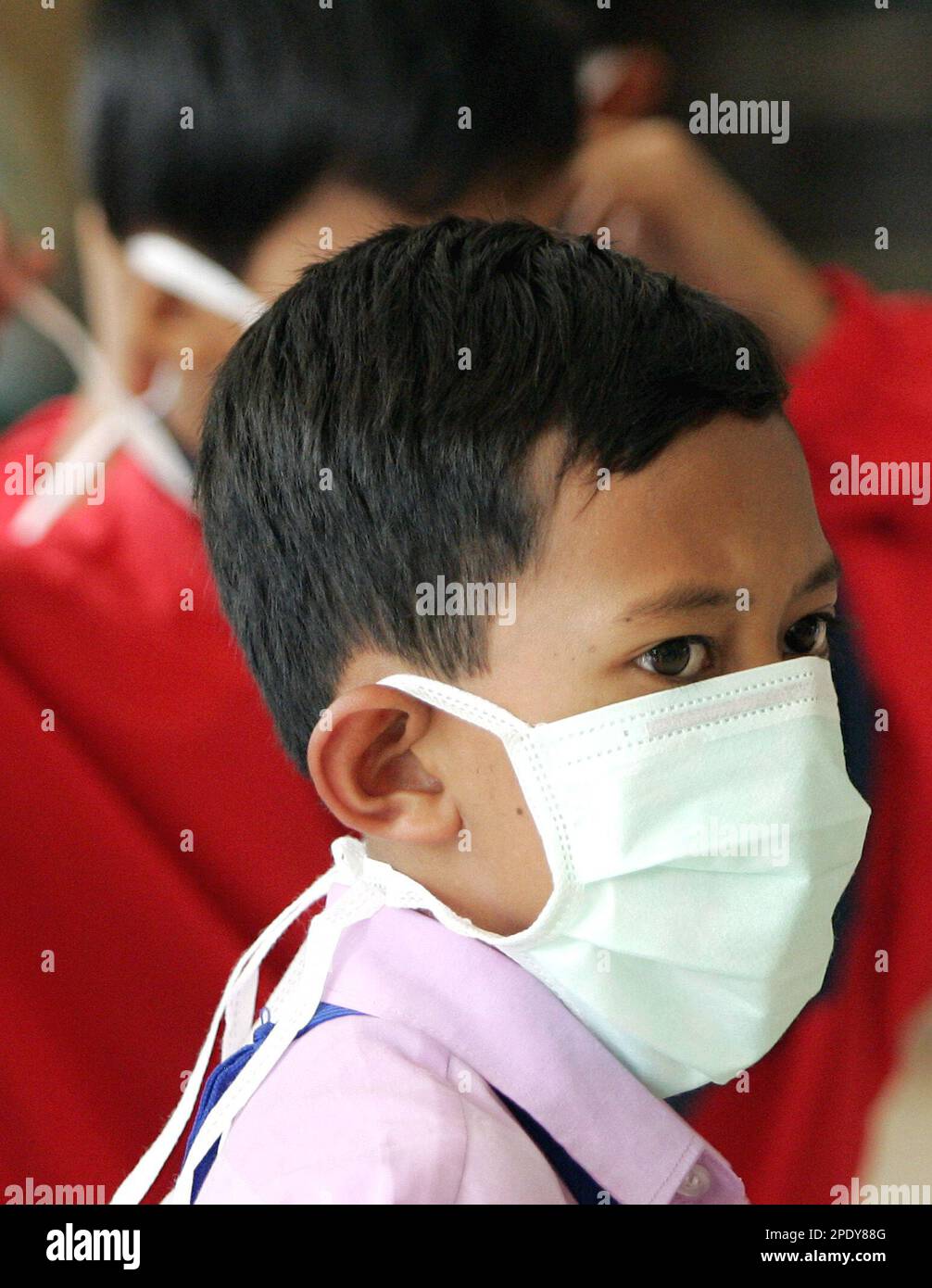 A schoolboy wears a protective mask to avoid breathing in dense haze at ...