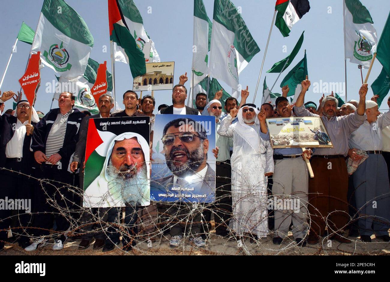 Hamas supporters hold posters of Hamas founder Sheik Ahmed Yassin, left ...