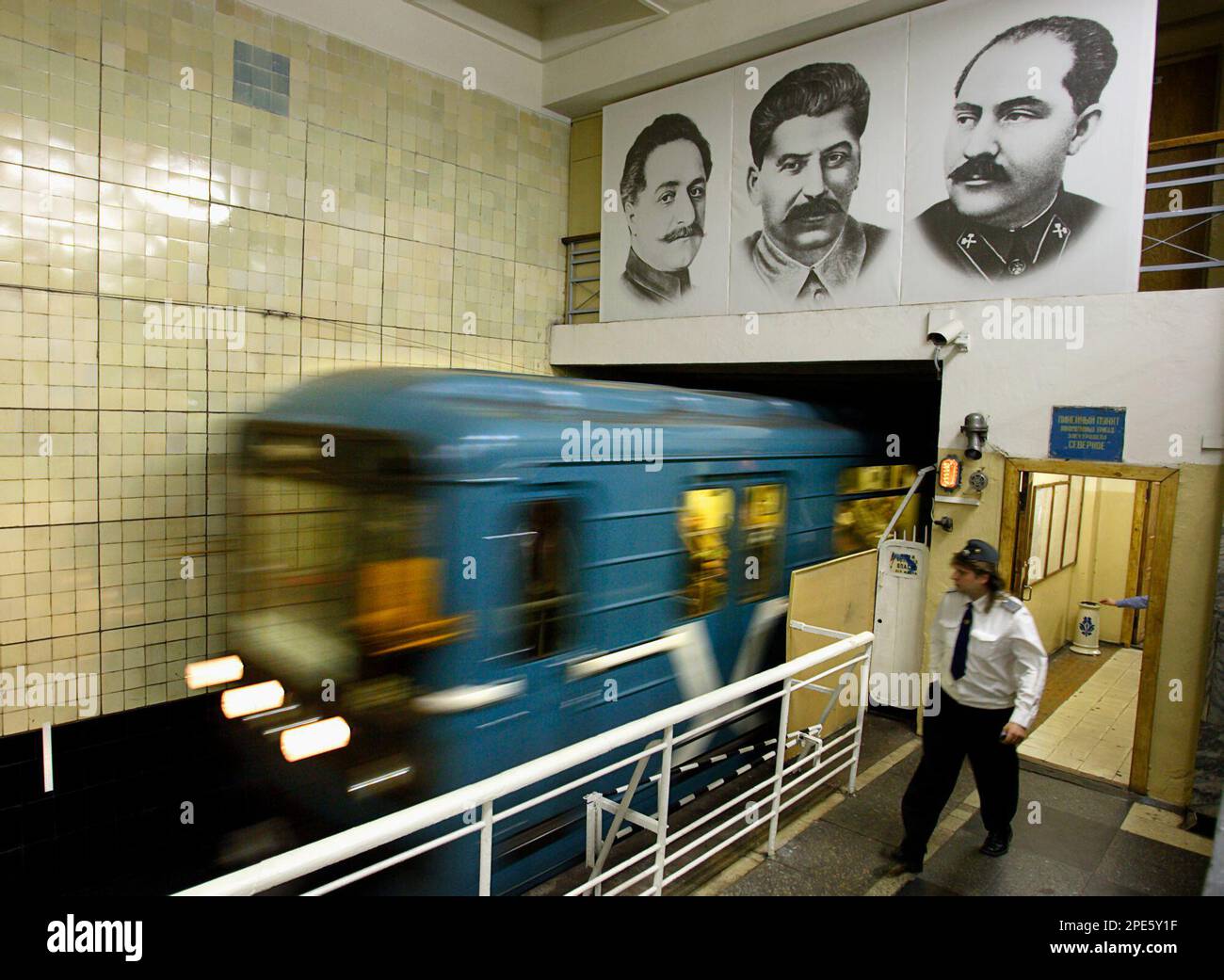 A train of the Russian capital's subway passes by large photos of, from ...