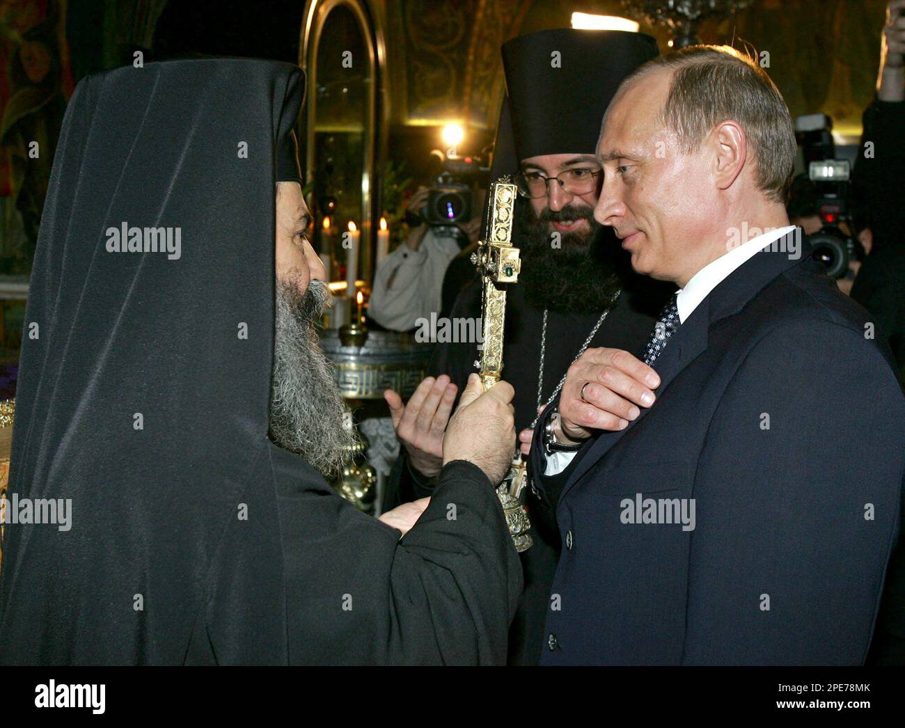 Russian President Vladimir Putin, right, crosses himself visiting the ...