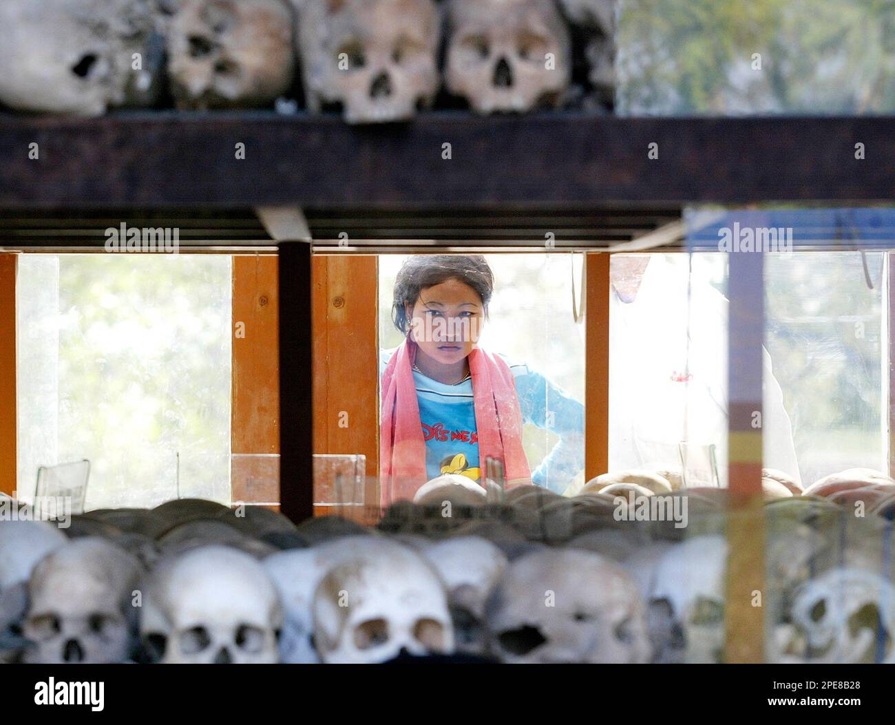 Cambodian girl looks at the skulls of Khmer Rouge victims on display at ...
