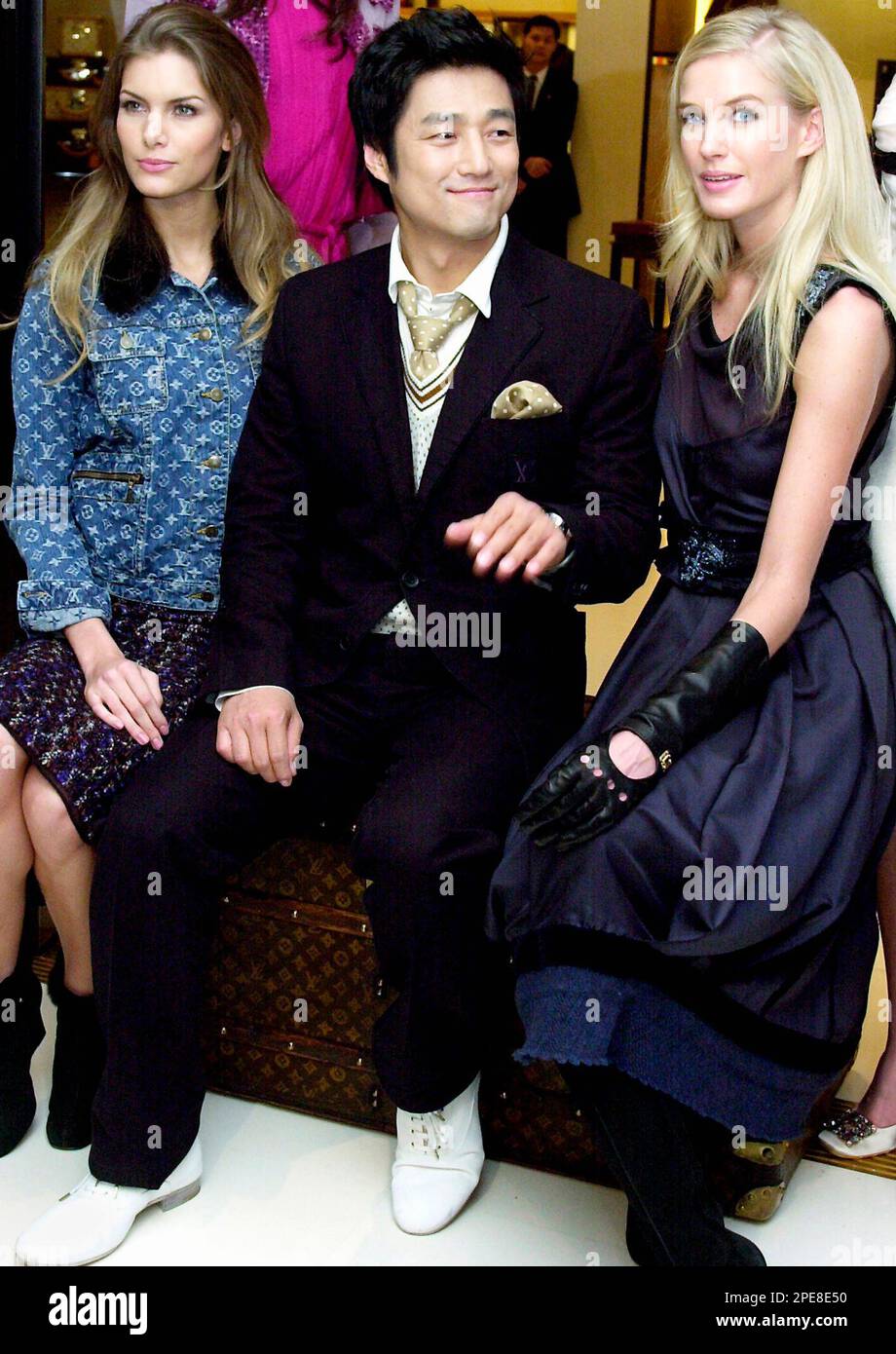 South Korean actor Ji Jin-hee poses with two models in Hong Kong on ...