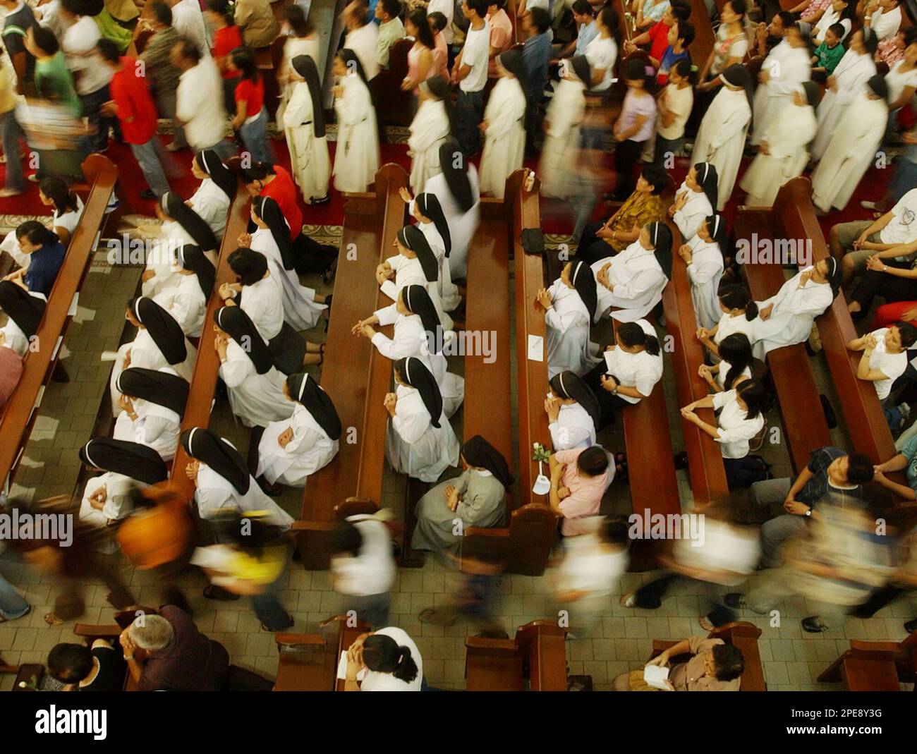 Filipino nuns kneel while others stand in line during a mass for late ...