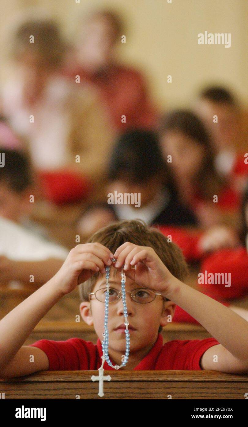 St. Teresa Catholic School student Kobe Christenson prays the rosary ...