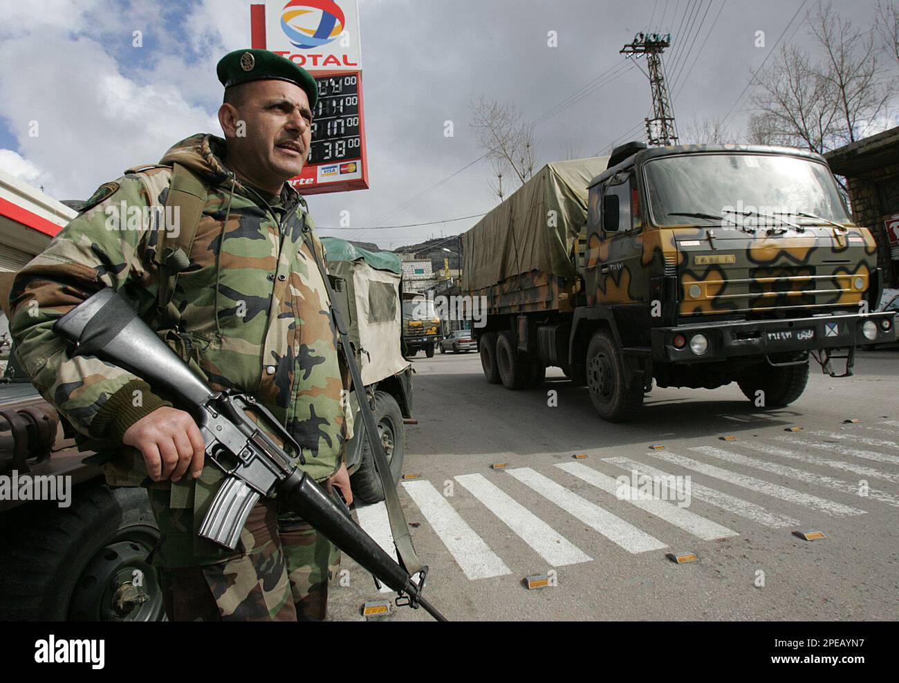 Lebanese soldier, left, stand guards as a Syrian truck passes by ...