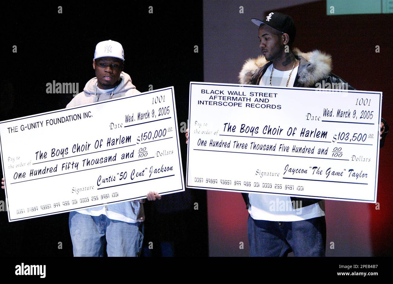 Rap artists 50 Cent, left, and The Game, hold checks during a news ...