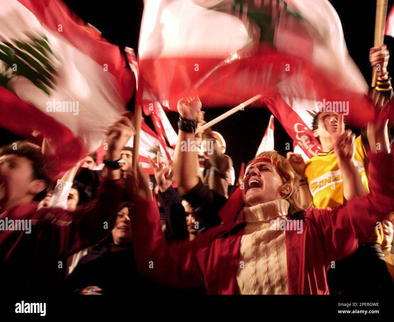 Lebanese protestors wave national flags and celebrate as they watch the ...