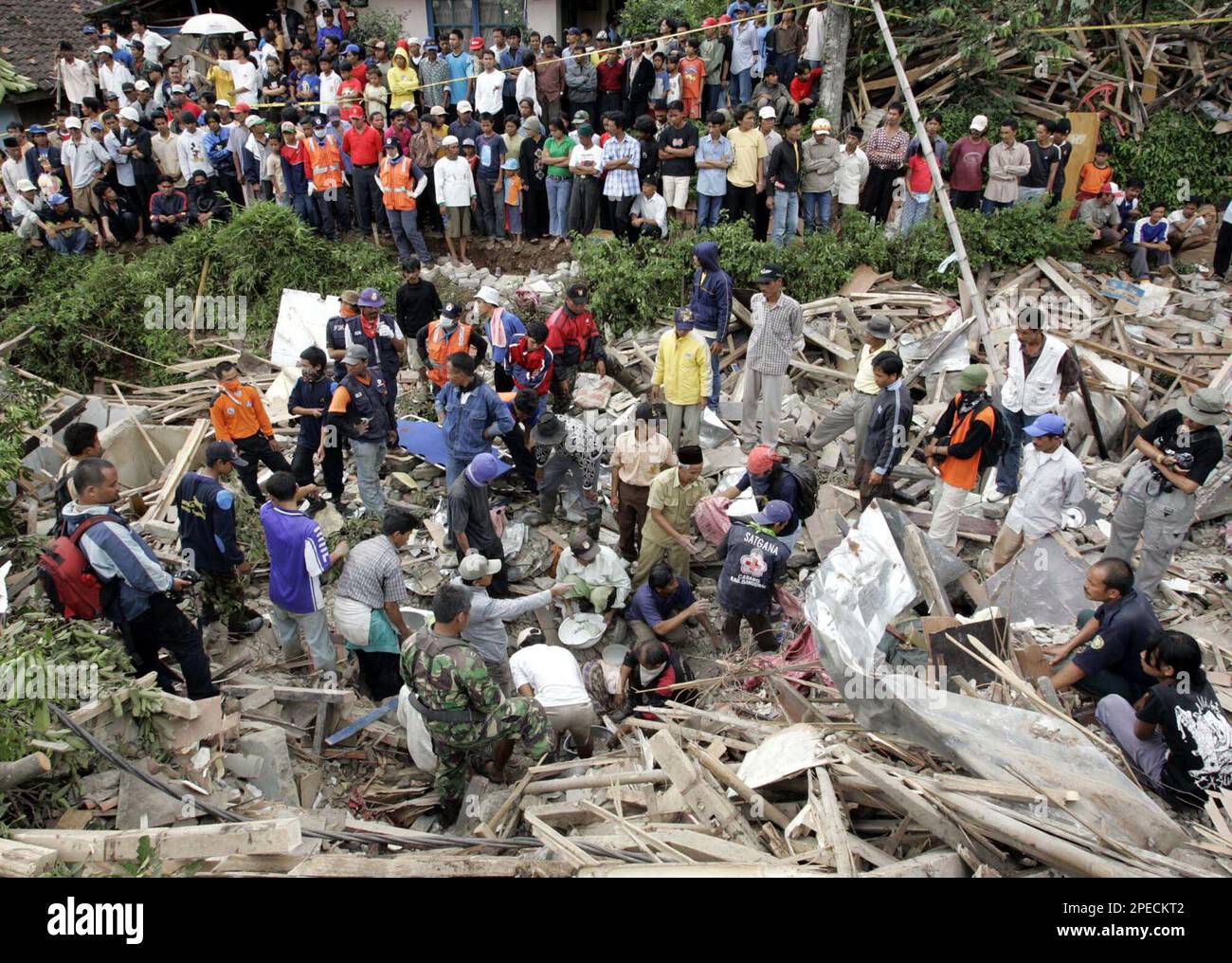Rescue workers retrieve victims from the wreckage of houses after mounds of garbage collapsed ...