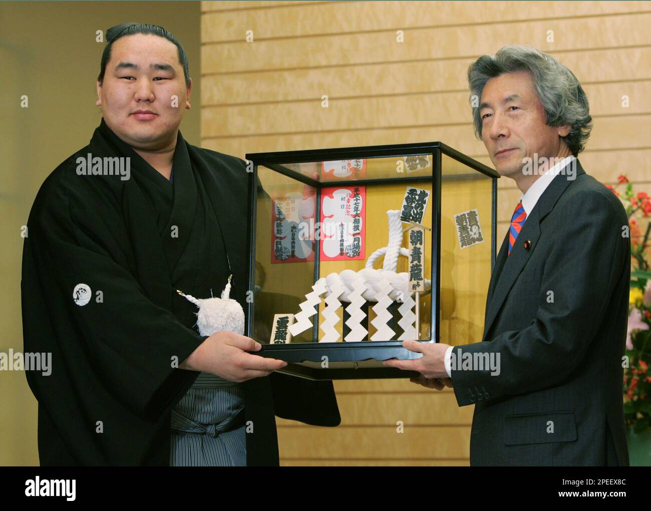 Sumo's grand champion Asashoryu, left, presents a miniature replica of ...