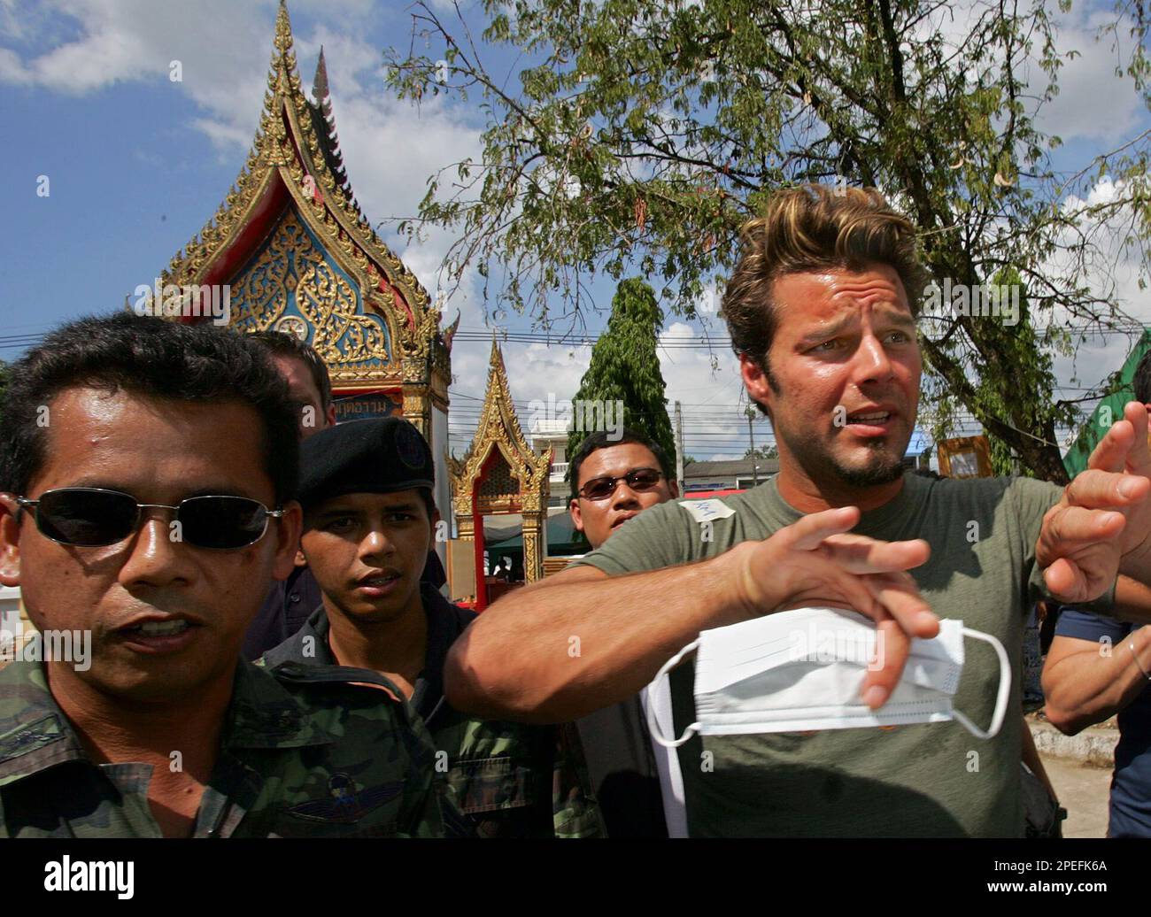 Pop star Ricky Martin holds a mask as he walks in a makeshift morgue ...