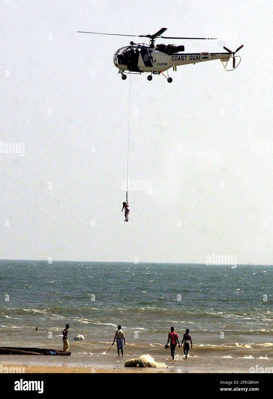 An Indian Coast Guard helicopter lifts the body of a victim who was ...
