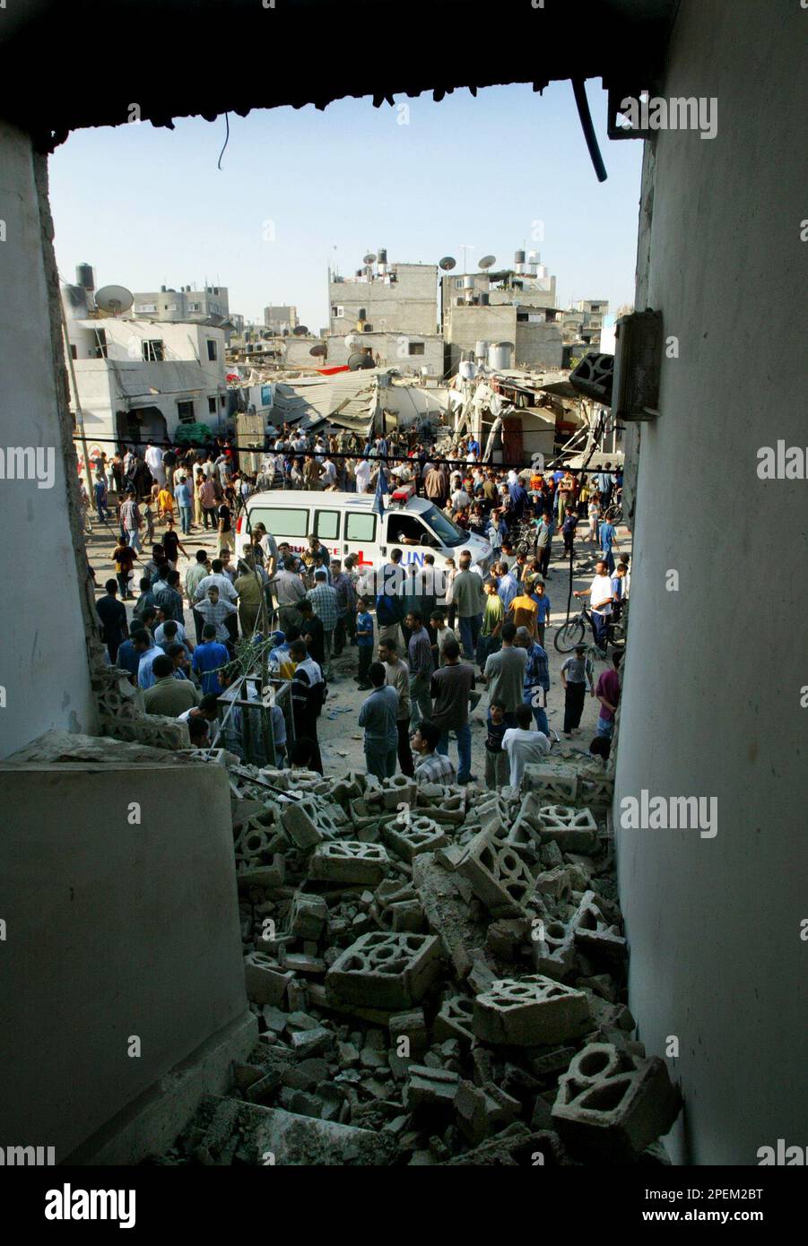 Palestinian residents gather in the rubble of destroyed houses ...