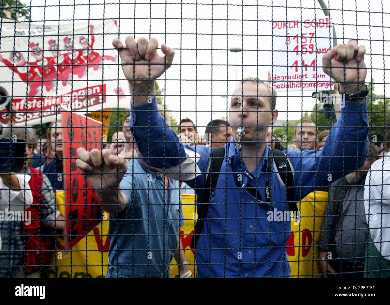 Gegen die Reform der Arbeitsmarktgesetze protestieren hinter einem Zaun ...