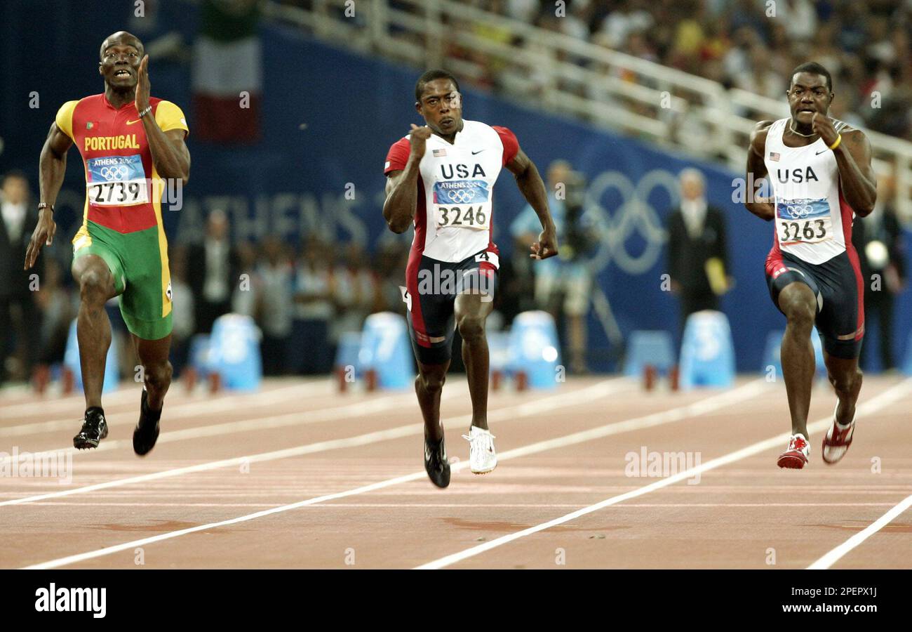Jason Gatlin, of the United States, right, crosses the finish line to ...