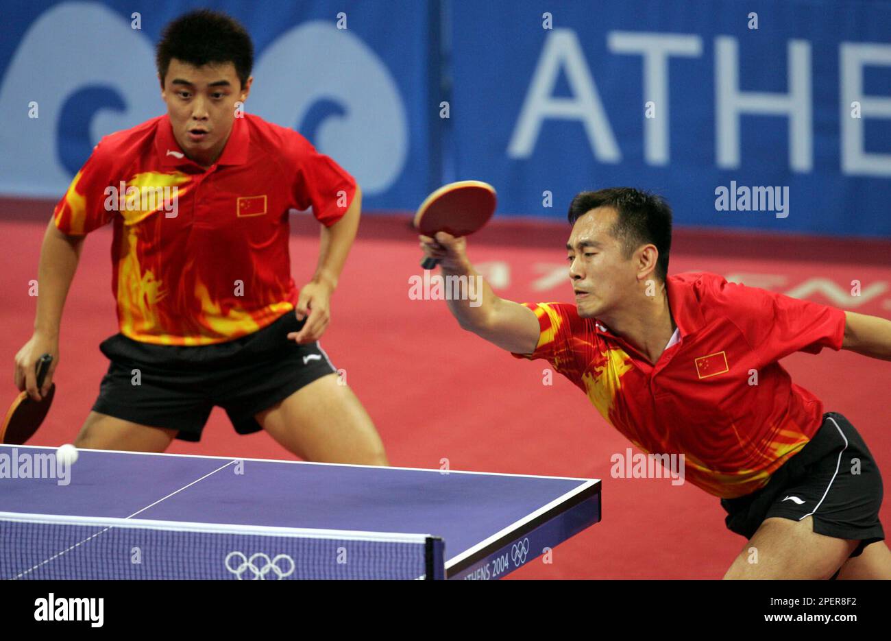 China's Kong Linghui, right, returns a shot as his teamate Wang Hao watching, against Sweden's ...
