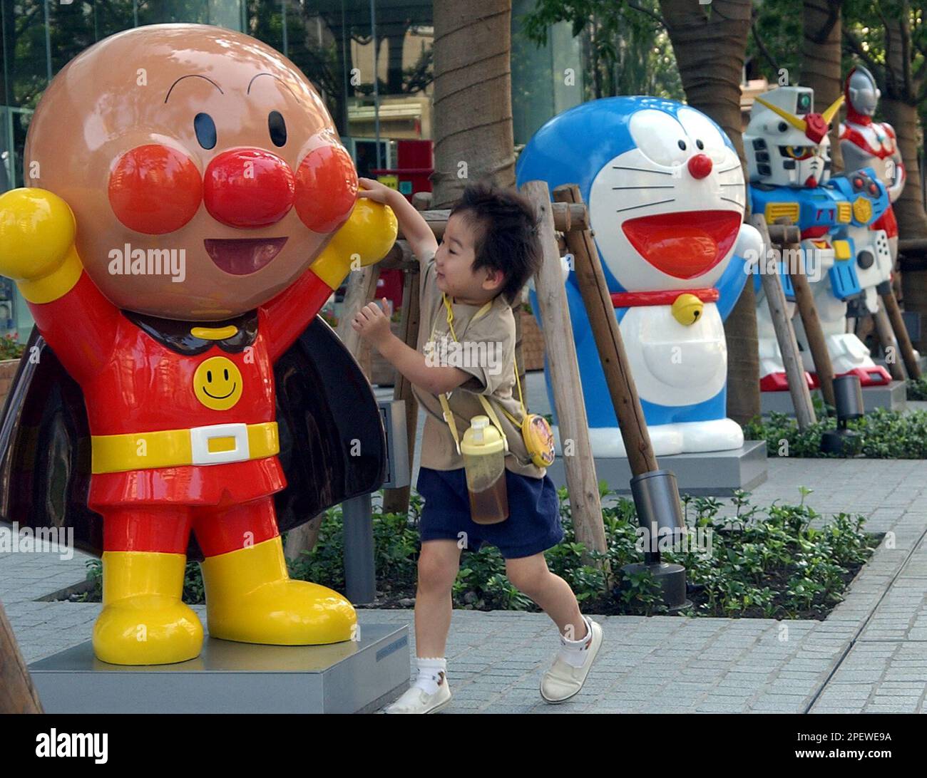 Shinnosuke Maruyama, aged 3, playfully touches on a doll of "Anpanman ...