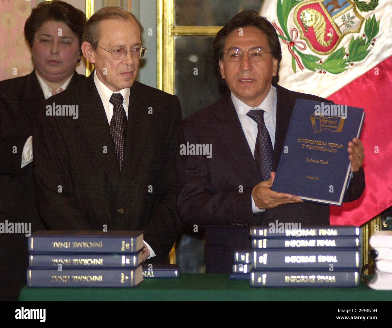 Peru's President Alejandro Toledo, right, holds one of nine volumes ...