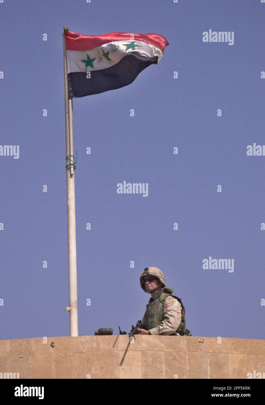 The Iraqi flag flies as a U.S. Army soldier belonging to the 2nd squad ...