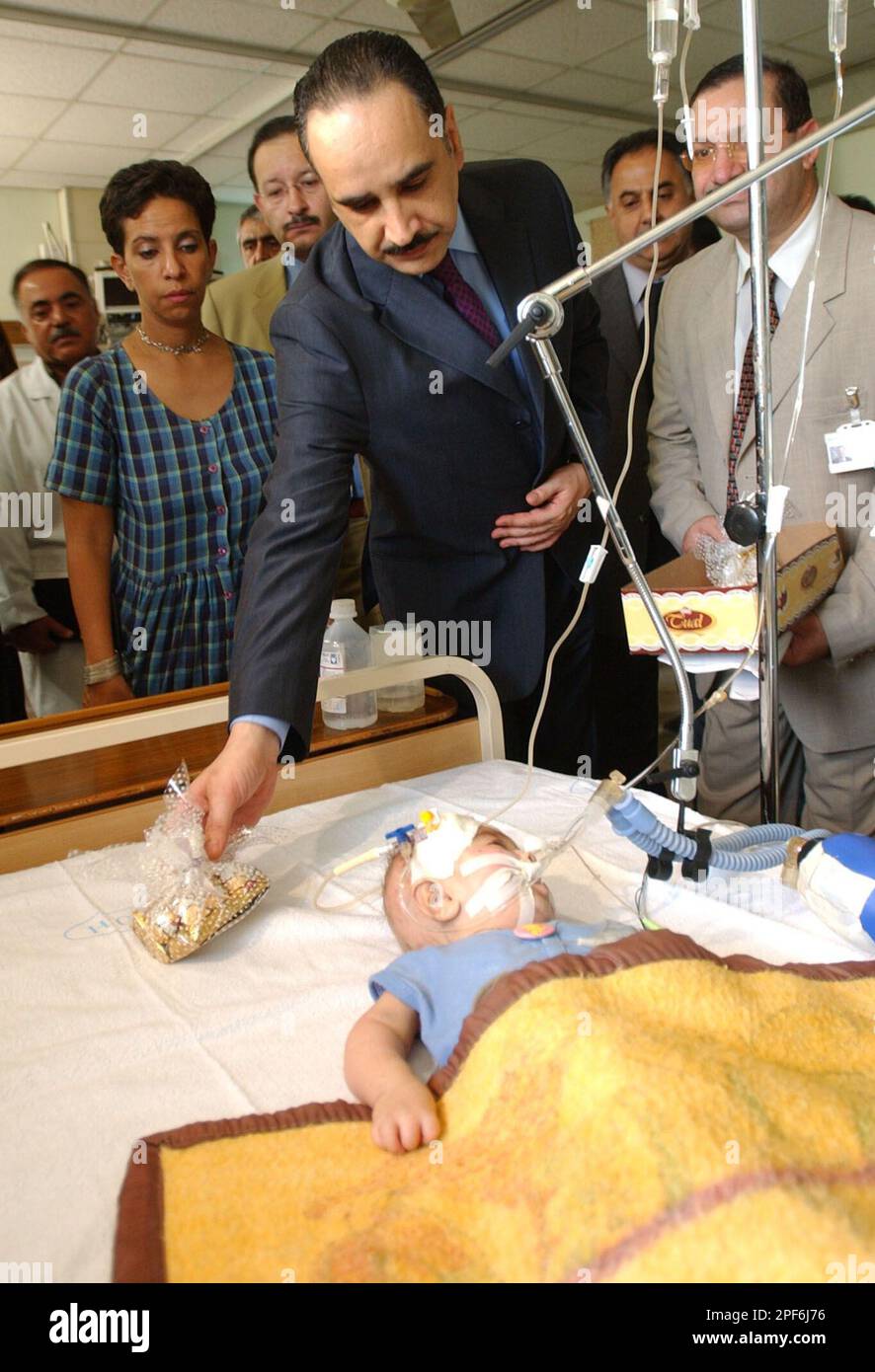 Sharif (Prince) Ali Bin al-Hussein places a gift beside a bedridden ...