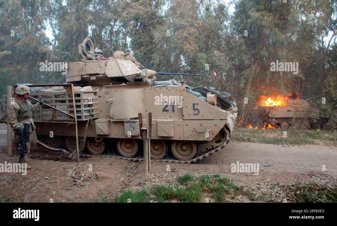 An Iraqi armored personel carrier burns as an American Bradley fighting ...