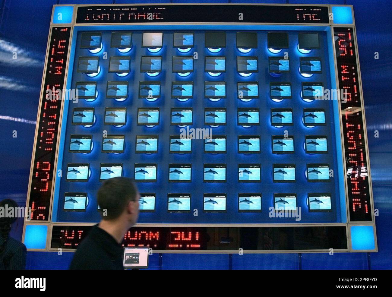 Ein Besucher geht an einer Monitor-Wand vorbei am Stand des Elektronik ...