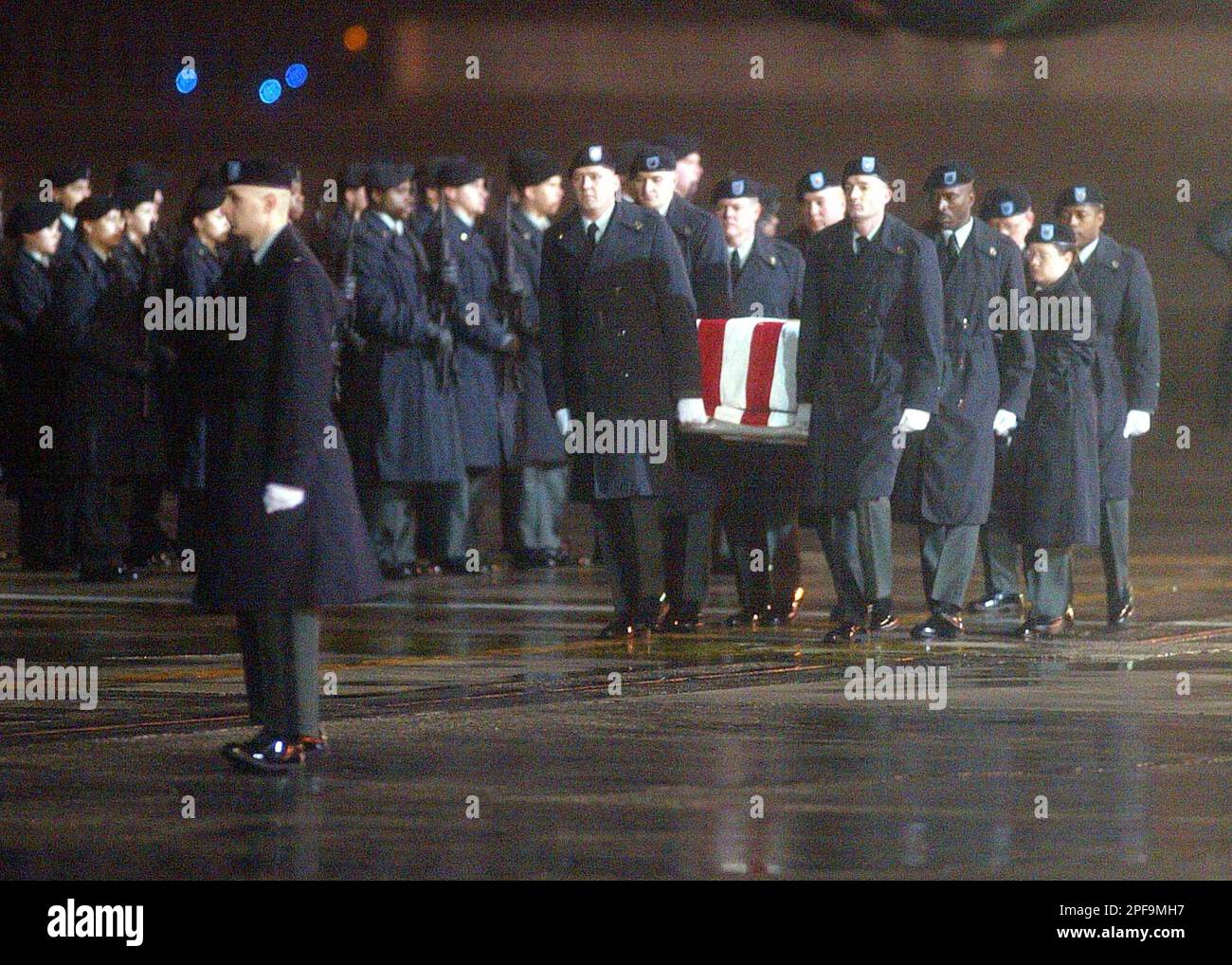 The flag-draped coffin of a killed U.S. soldier is carried pass a honor ...