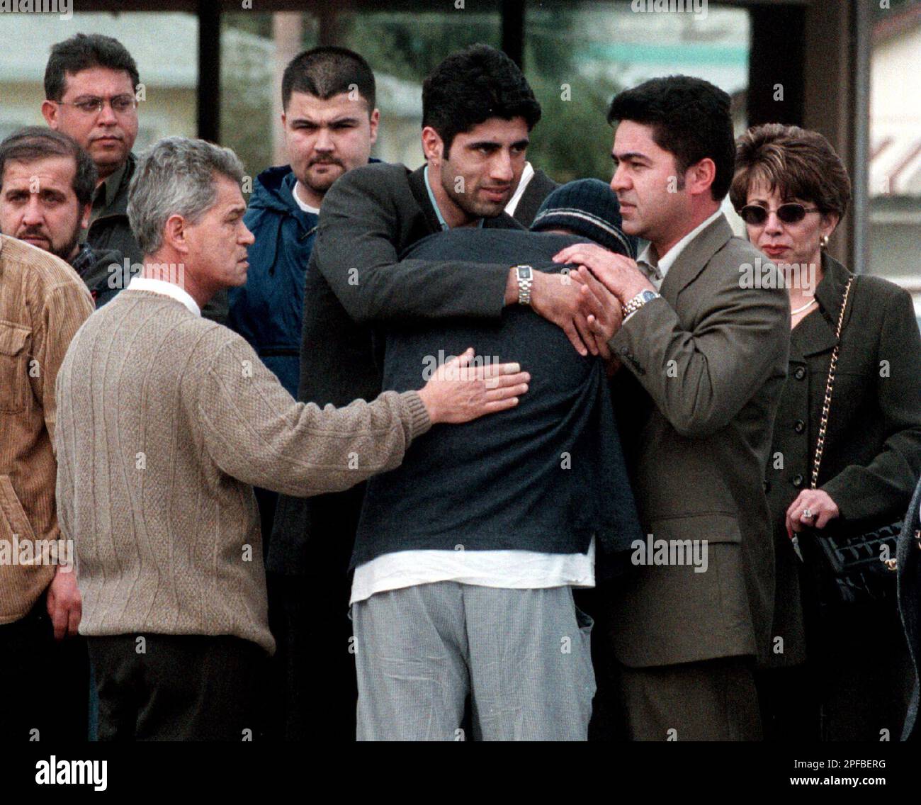 Friends and family members surround Fahim Ansari, center, the youngest ...