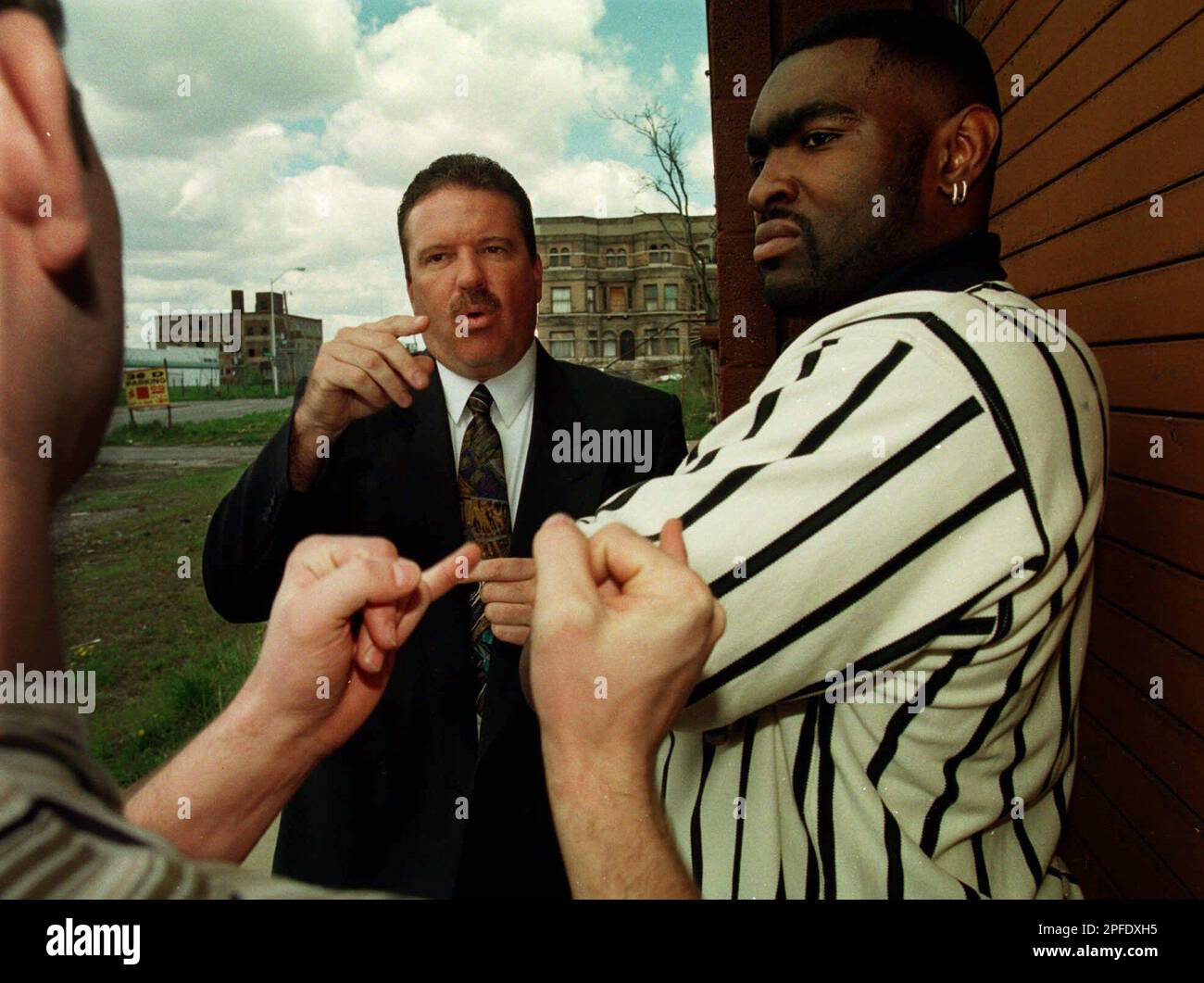 Detroit police officer Thomas Dunaj, center, using sign language ...