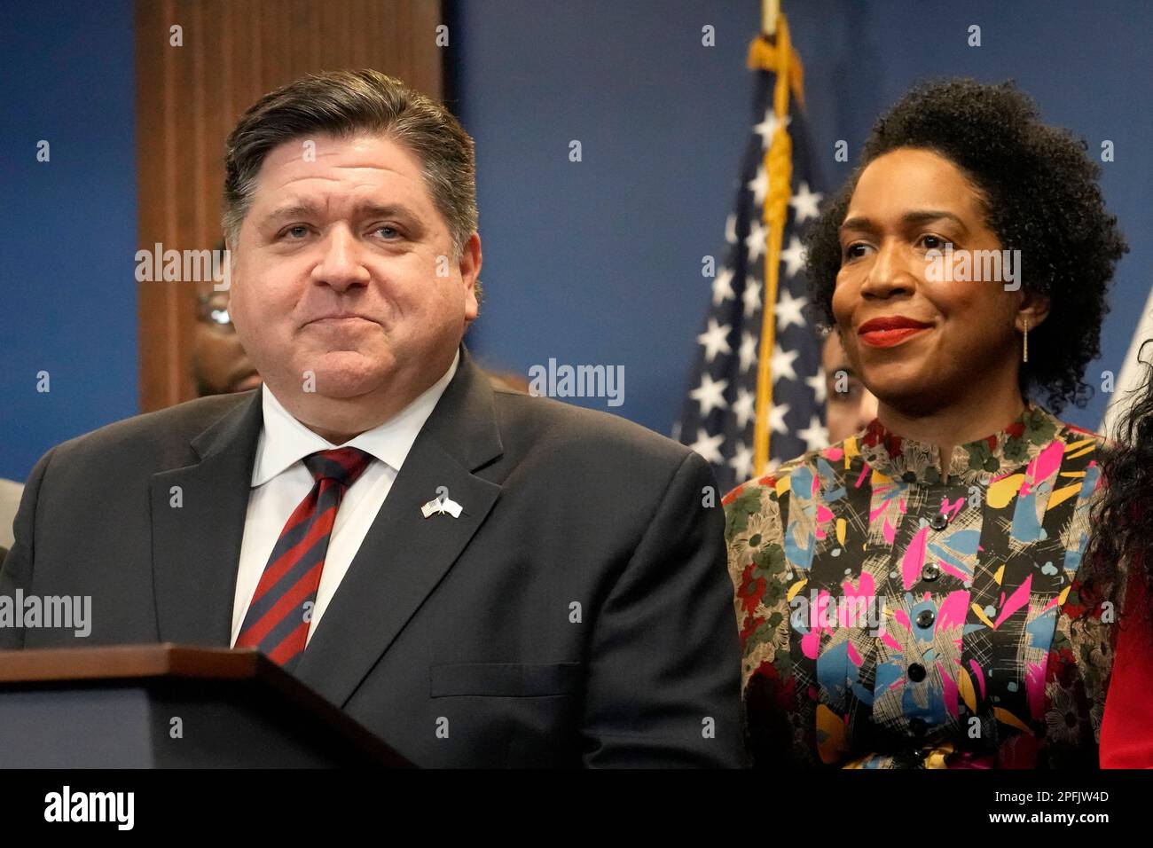 Illinois Gov. J.B. Pritzker smiles and stands with Lt. Gov. Juliana ...
