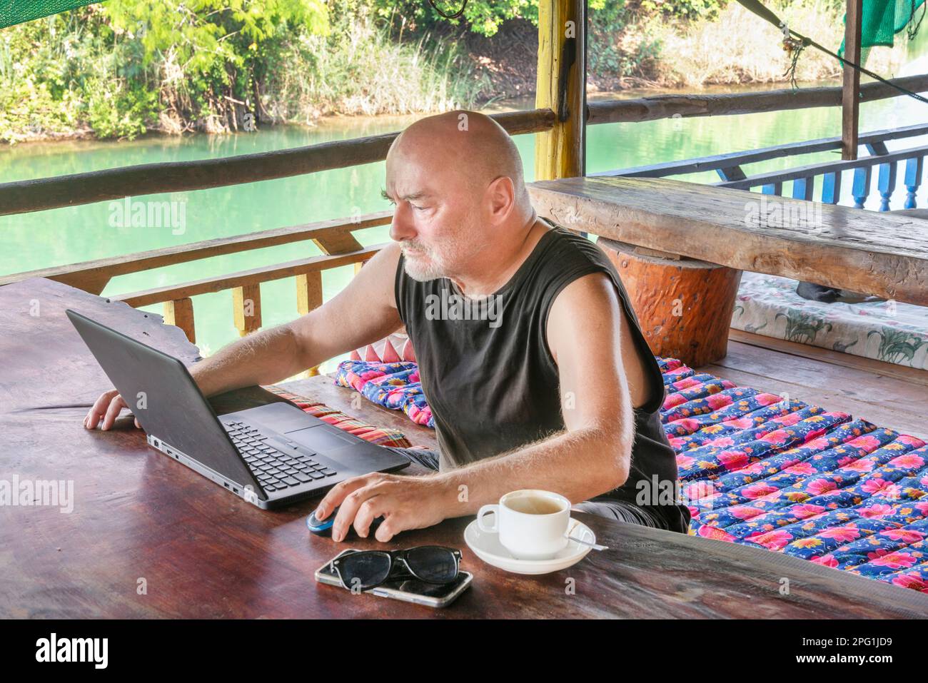 Er arbeitet aus der Ferne an seinem Computer bei Si Phan Don, ein Mann ...