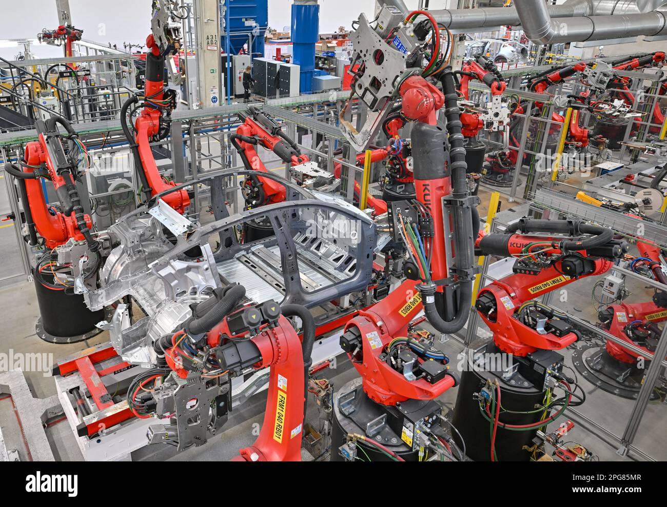 20. März 2023, Brandenburg, Grünheide: Roboter schweißen die Karosserie ...