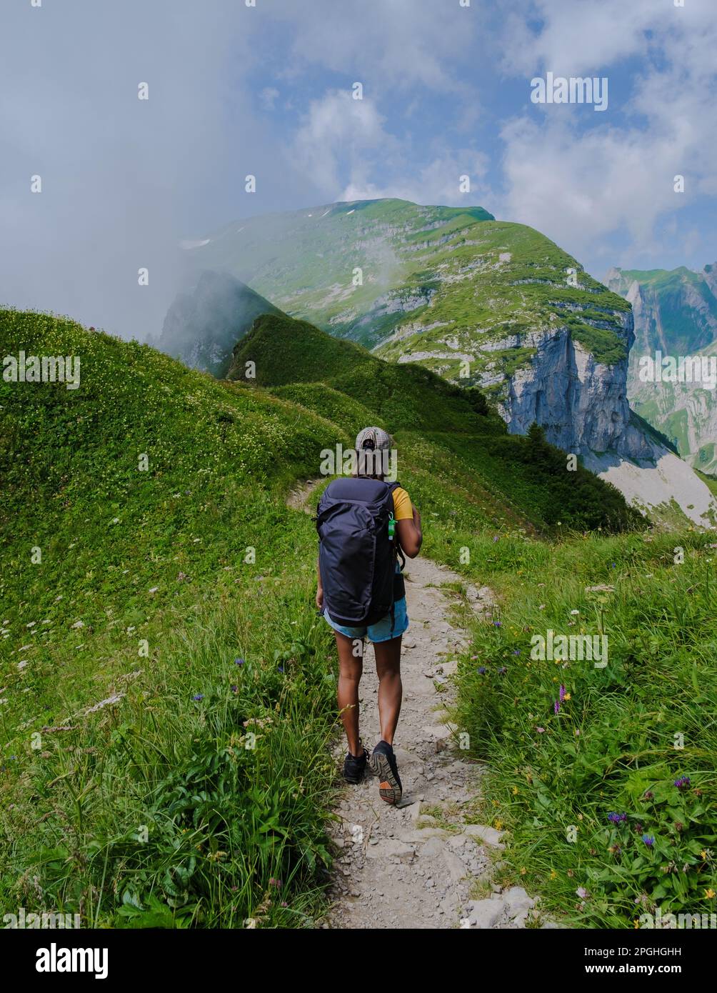 Asiatische Frauen wandern im Sommerurlaub in den Schweizer Alpen mit ...