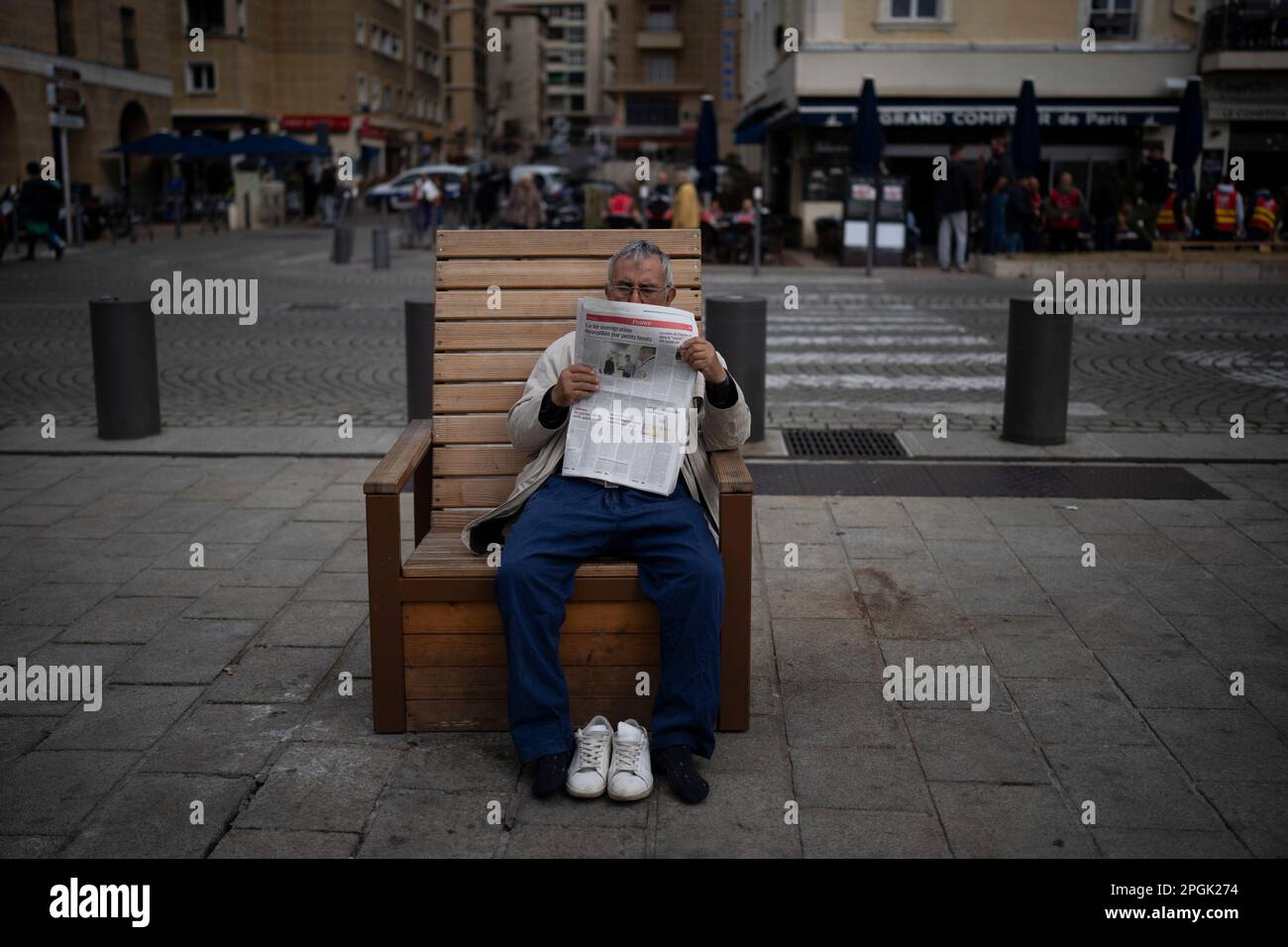 A man reads a newspaper before the start of a rally in Marseille ...