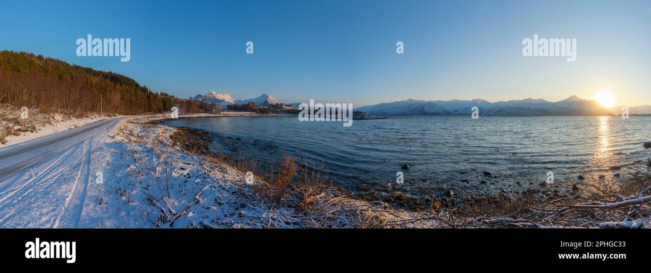Abendrot mit einem hellen Sonnenstrahl über den verschneiten Bergen von ...