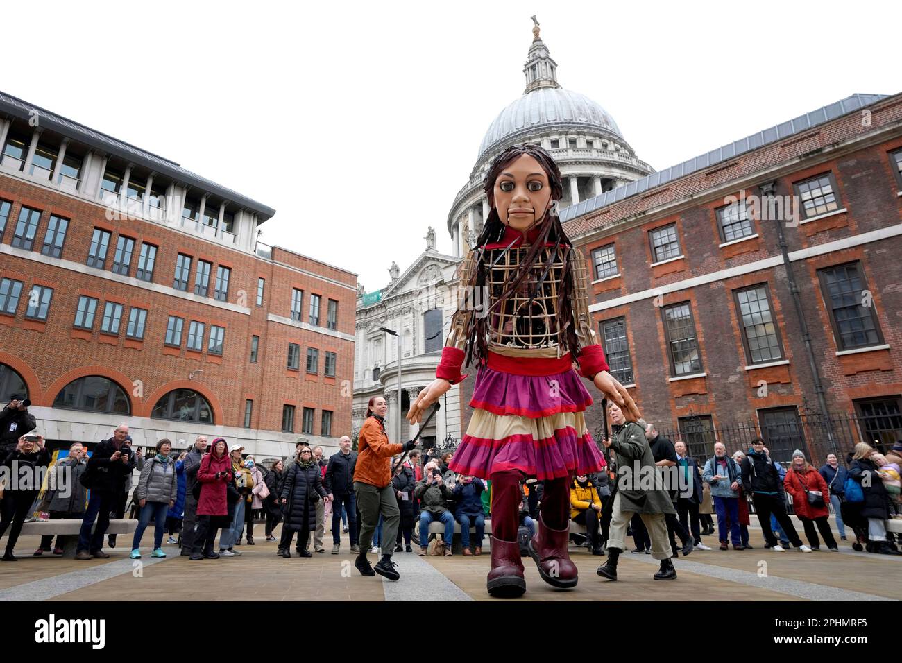 People watch as the puppet called Little Amal performs in Paternoster ...