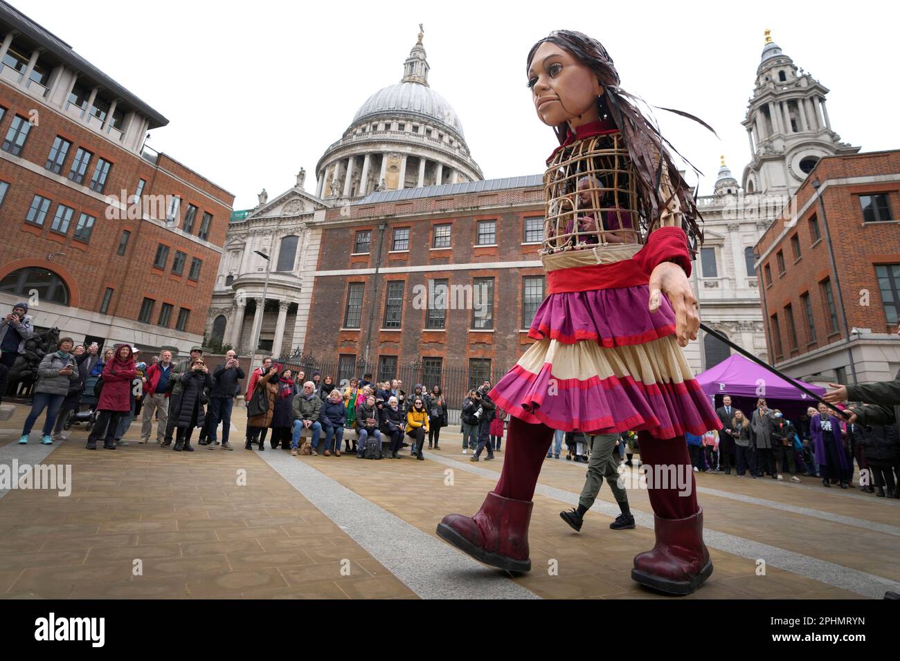 People watch as the puppet called Little Amal performs in Paternoster ...