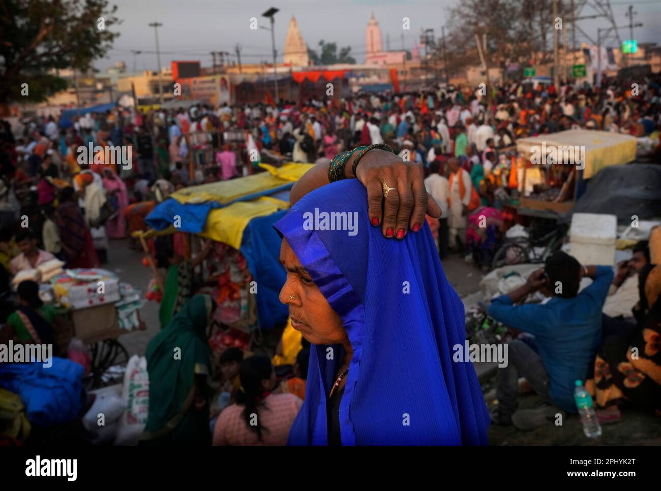 A woman waits for family members before going for a holy dip in the ...