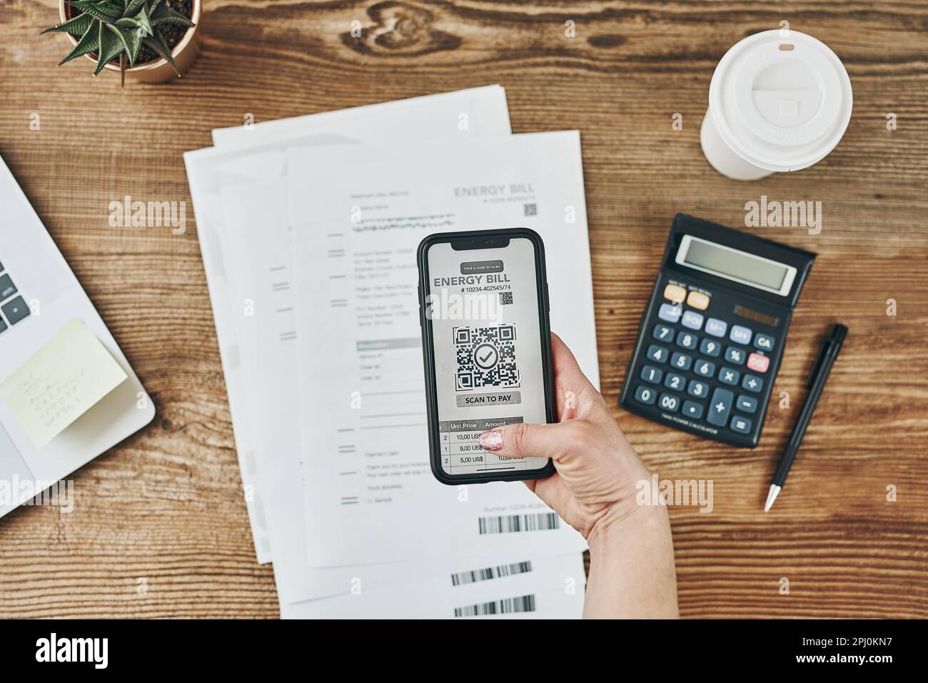 Eine Frau, die für Energie bezahlt und den QR-Code von der Rechnung ... Eine Frau, die für Energie bezahlt und den QR-Code von der Rechnung ...