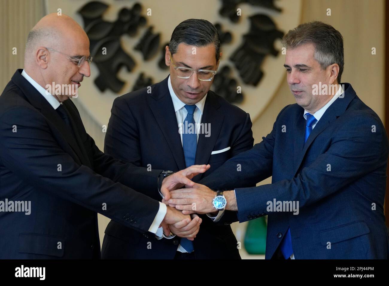 Cyprus Foreign Minister Constantinos Kombos, center, shake hands with ...