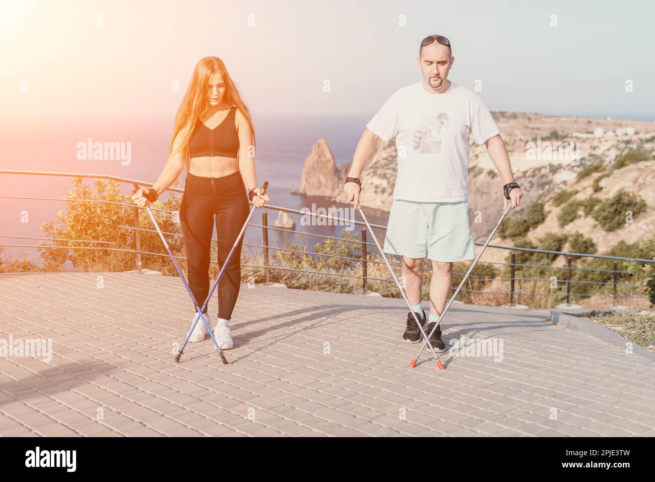 Glückliches Paar mittleren Alters oder Freunde, die nordic Walking im Park in der Nähe des ...