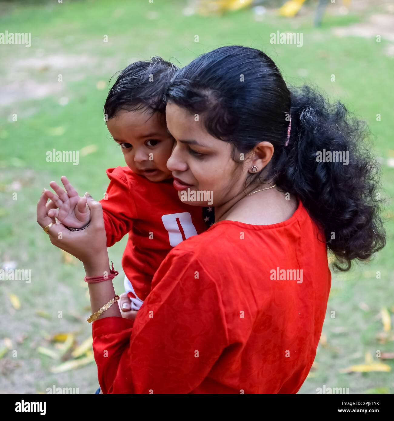 Liebende mutter, die ihr Baby im Society Park trägt. Helles Porträt ...