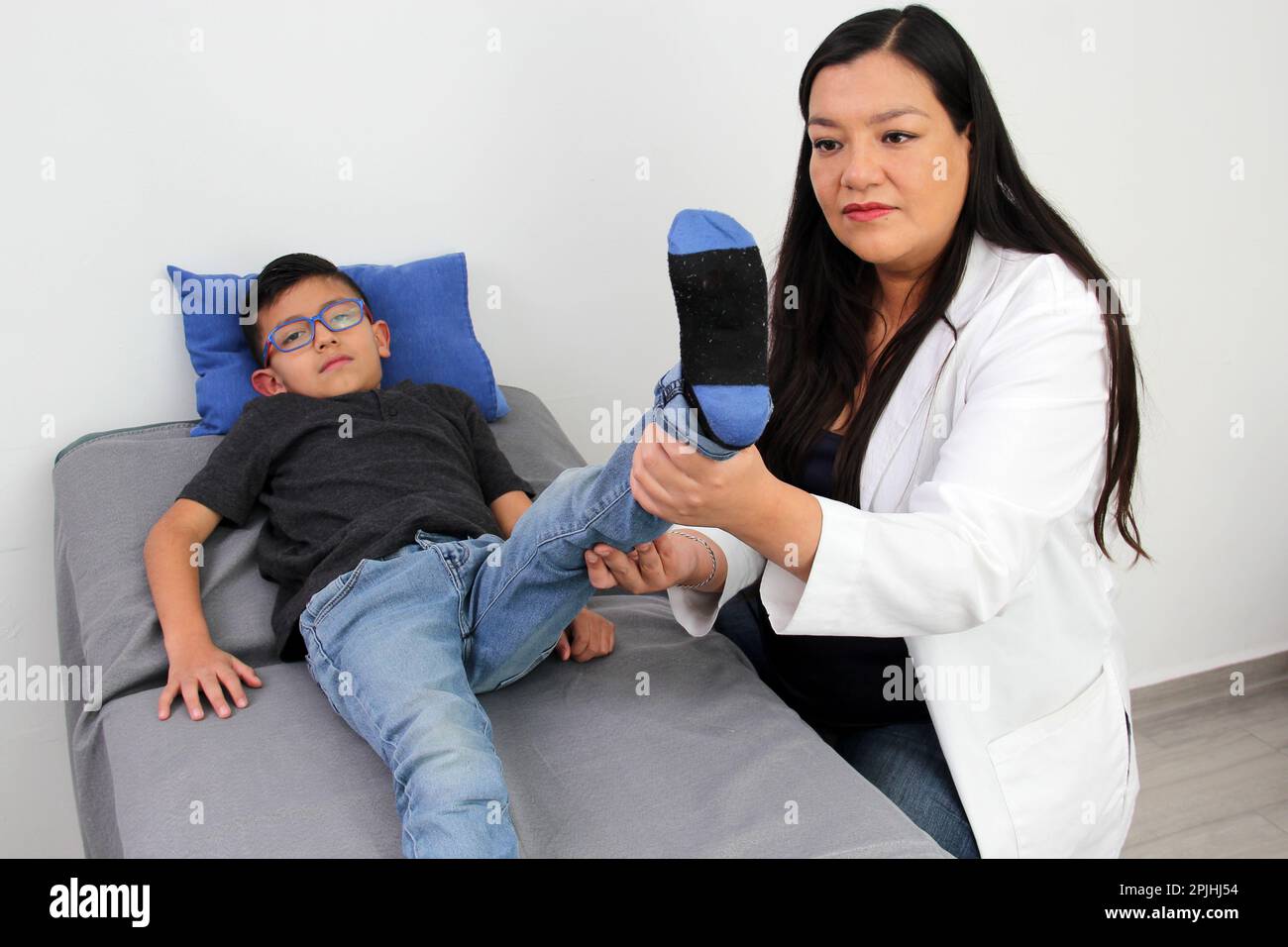 Latina Kinderärztin Ärztin besucht einen 7-jährigen Jungen in ihrer ...