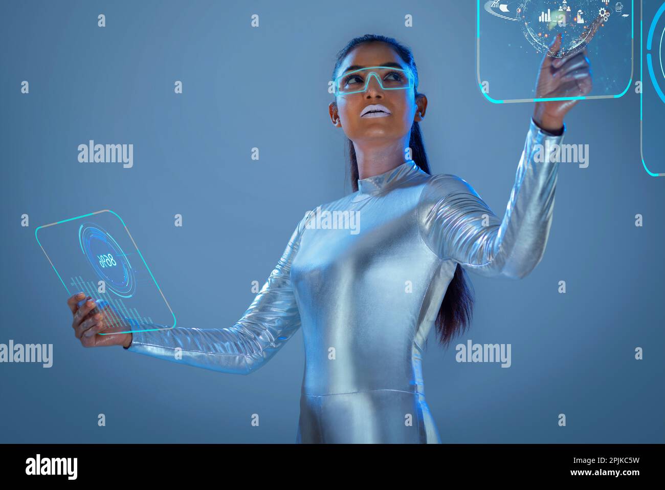 Ein Model, das als Roboter verkleidet ist und silberne, futuristische Kleidung trägt und ein ...