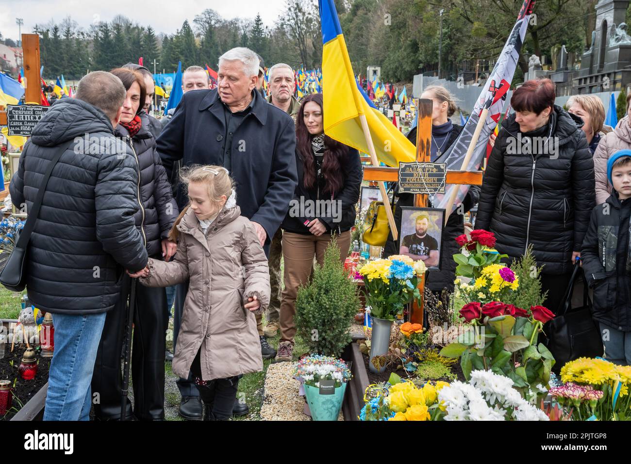 Die Menschen stehen in der Nähe des Grabes eines gefallenen Soldaten ...