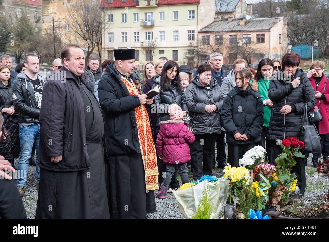 Die Menschen besuchen eine Gedenkfeier auf dem Friedhof in der Nähe des ...