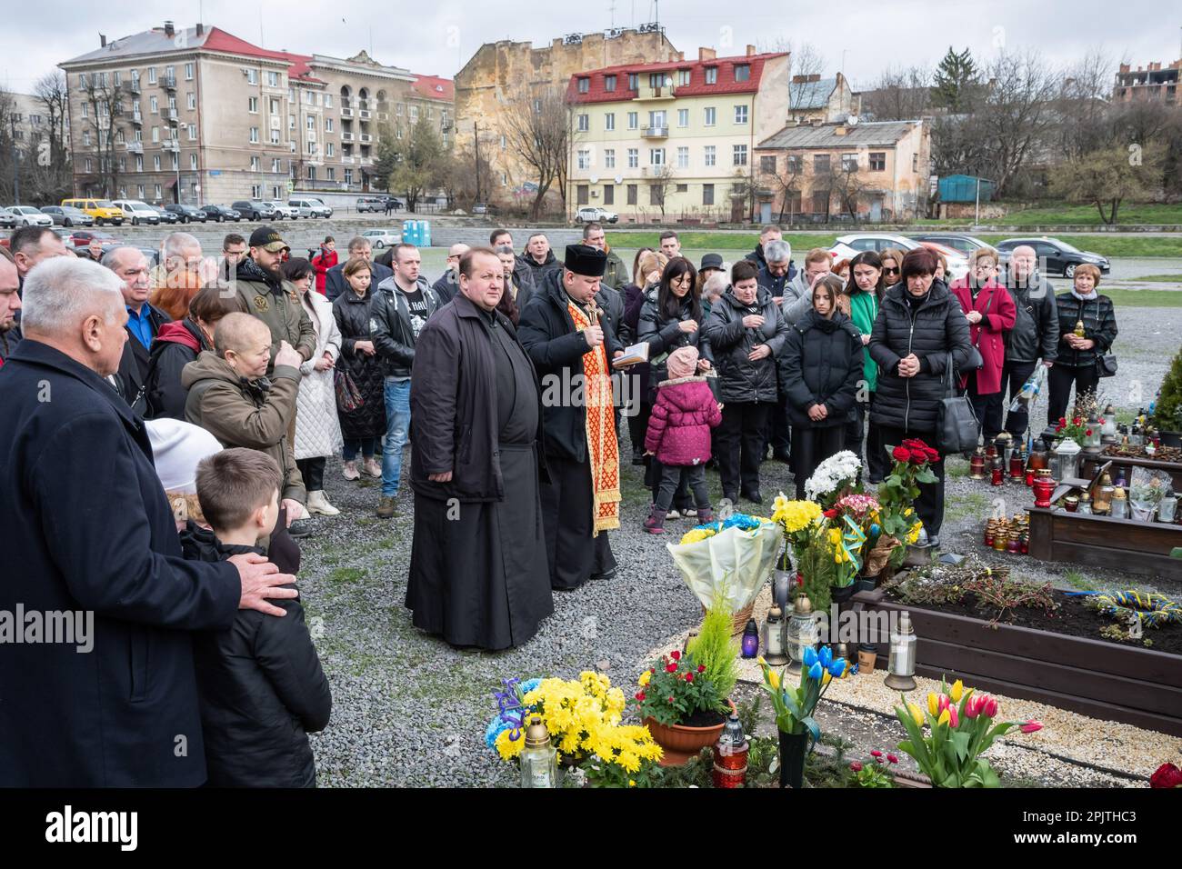 Die Menschen besuchen eine Gedenkfeier auf dem Friedhof in der Nähe des ...