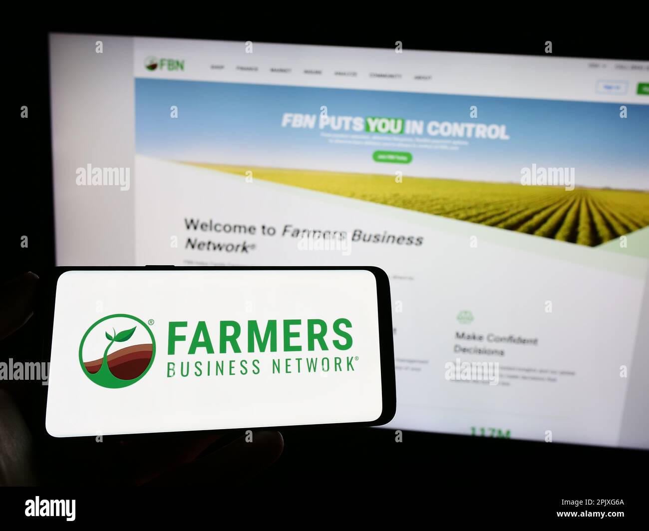 Person, die ein Mobiltelefon mit dem Logo der Landwirtschaftsplattform ...